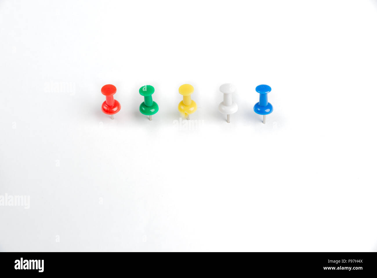 4 pins in a row on a white background Stock Photo - Alamy