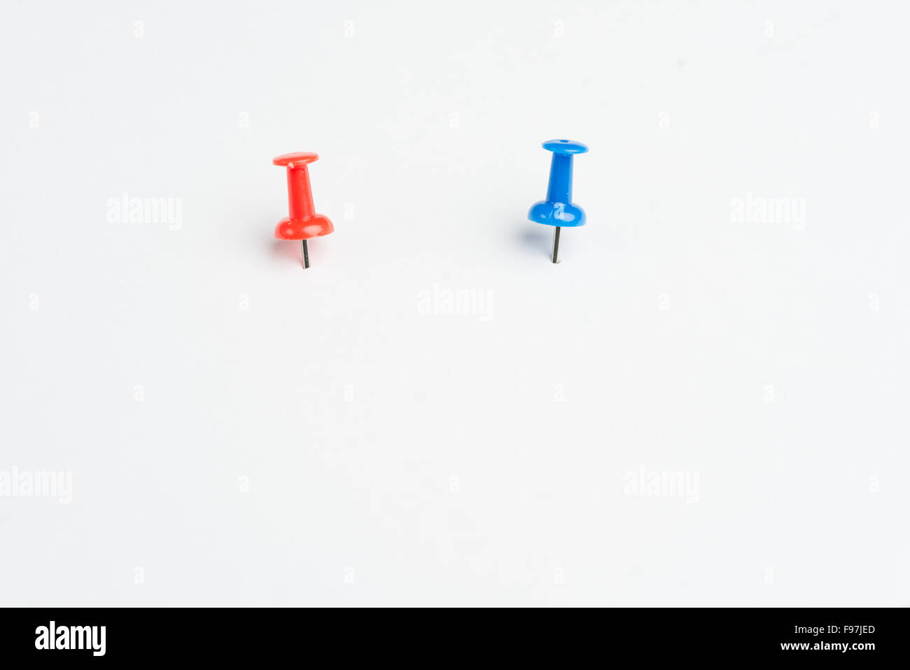 2 colored pins on a white background Stock Photo - Alamy