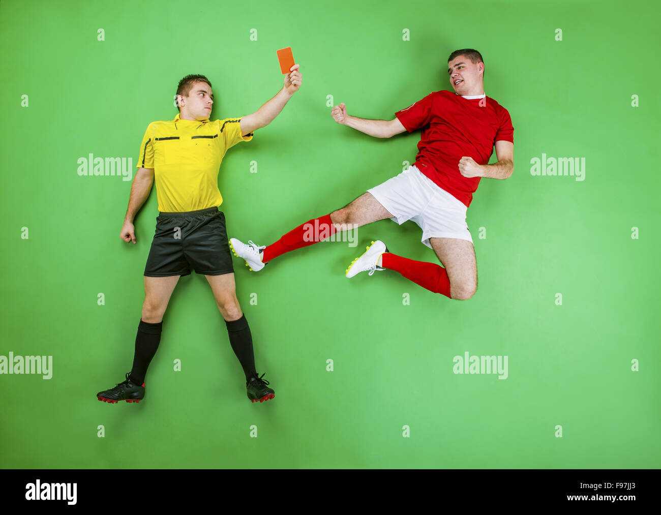 Referee giving red card to a football player. Studio shot on a green ...