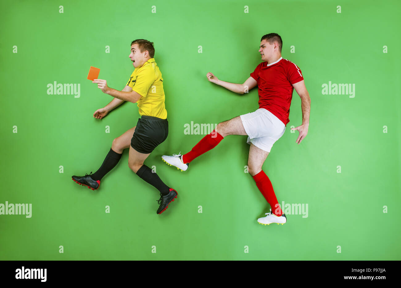 Referee giving red card to a football player. Studio shot on a green ...