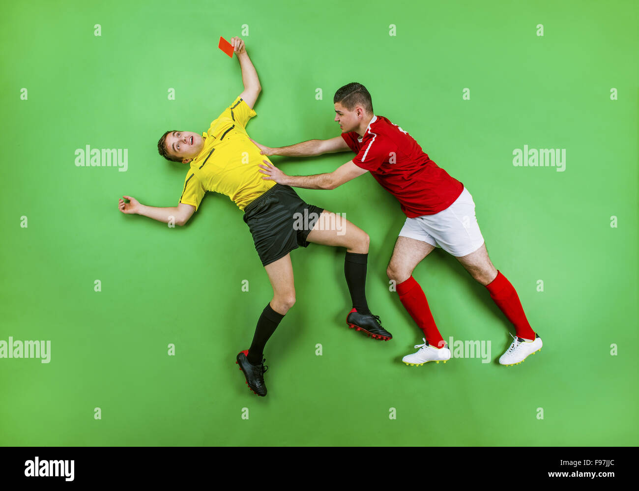 Referee giving red card to a football player. Studio shot on a green ...