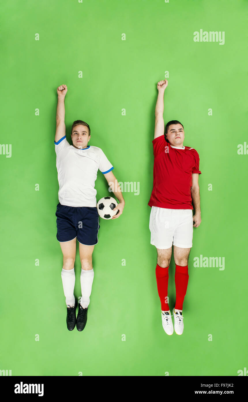 Two football players in a superman pose. Studio shot on a green ...