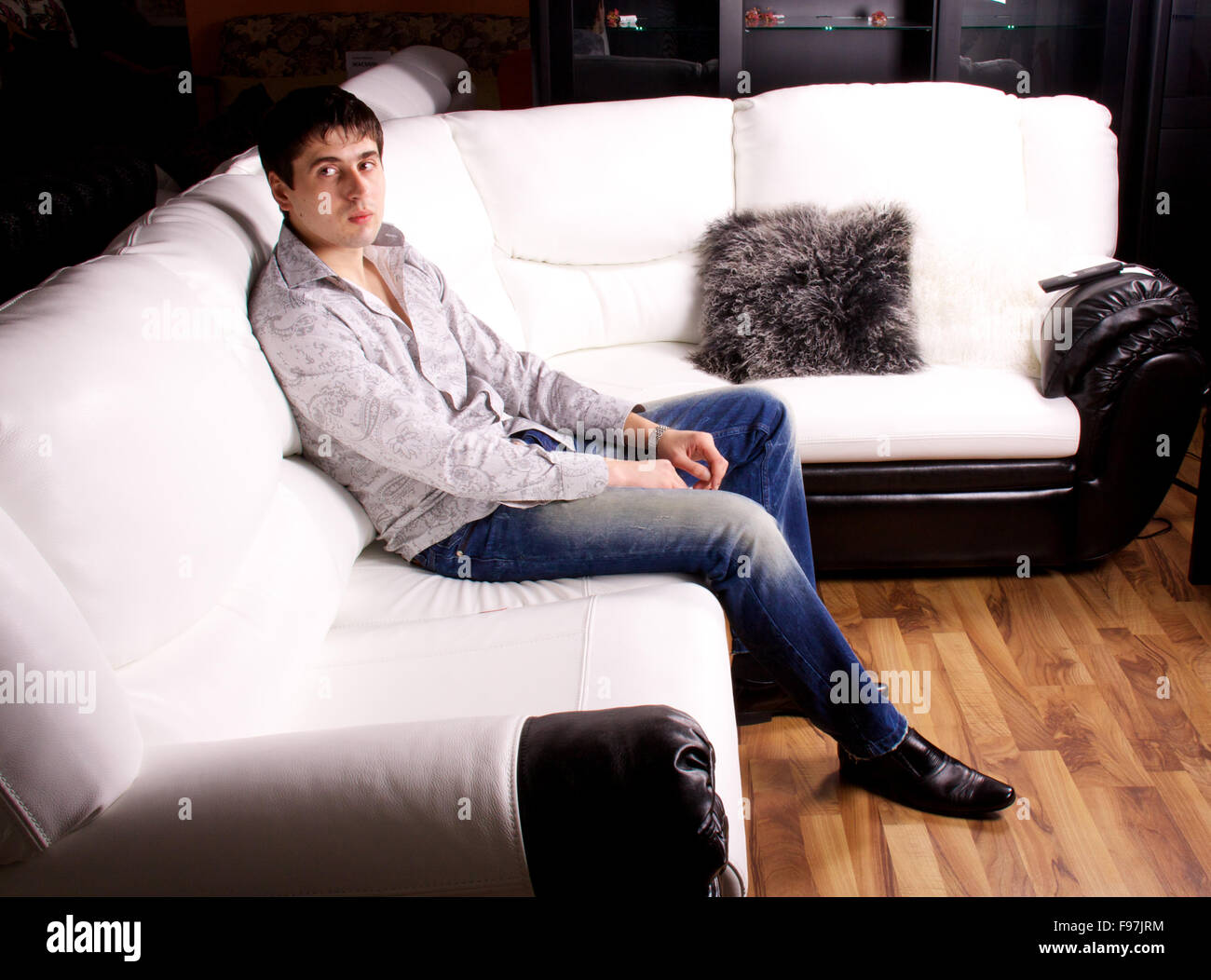 Handsome man sitting on a sofa Stock Photo - Alamy