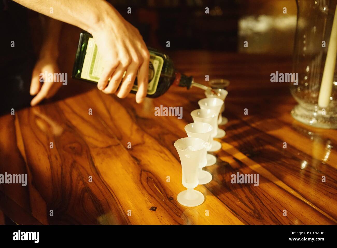 Cropped Image Of Person Pouring Alcohol In Wineglasses Stock Photo - Alamy