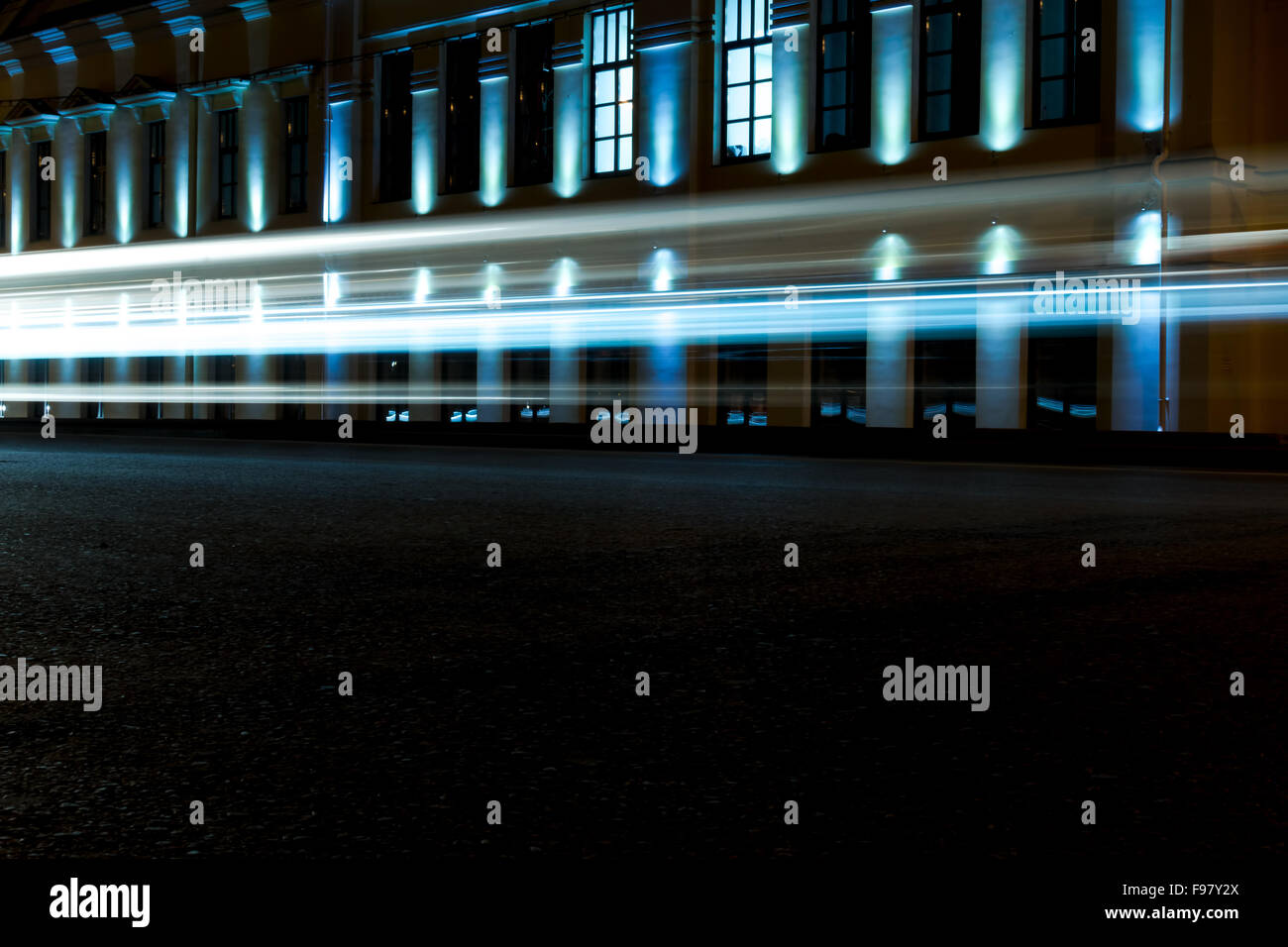 Cars create light electric blue light trails as they move past a neon ...