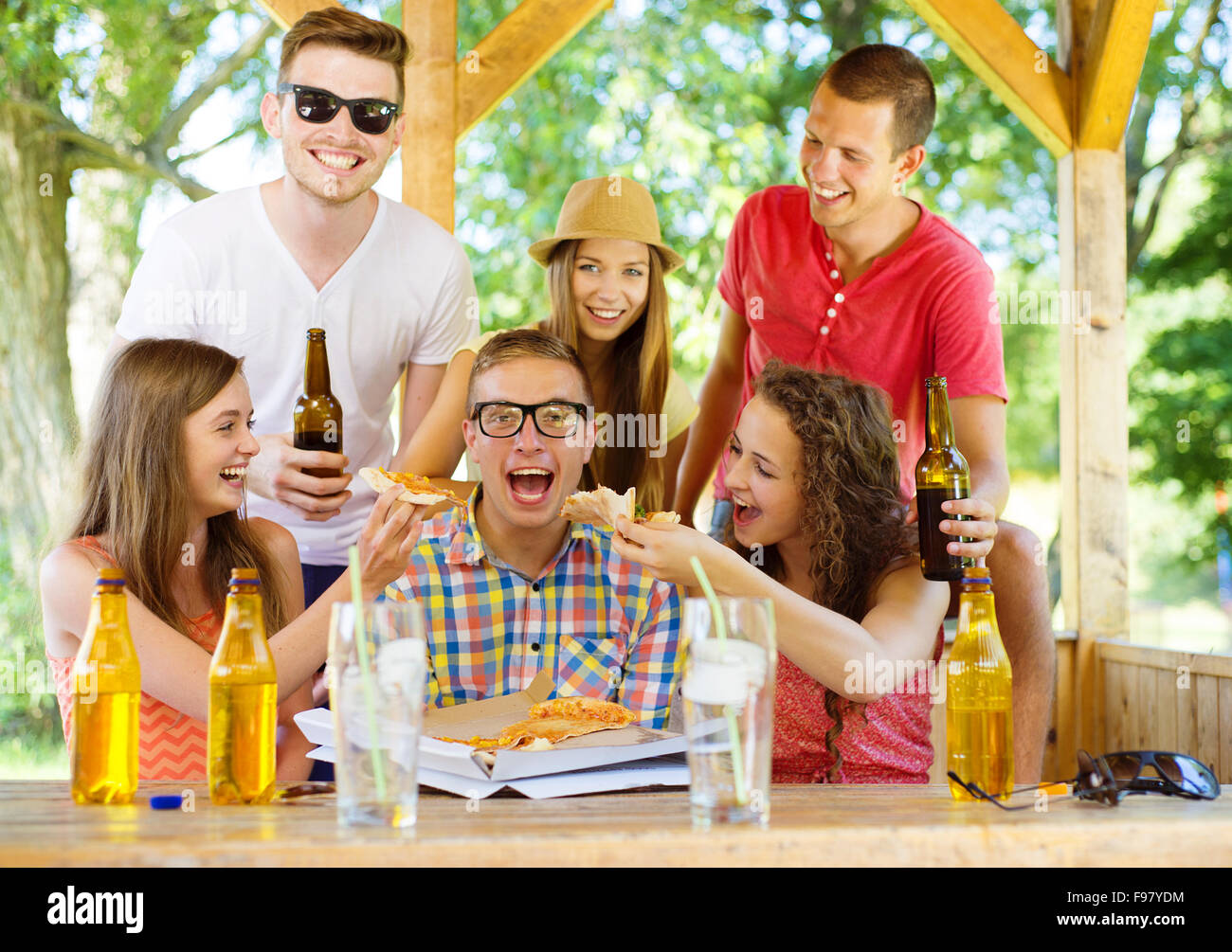 Group of happy friends drinking and eating pizza in pub garden Stock ...