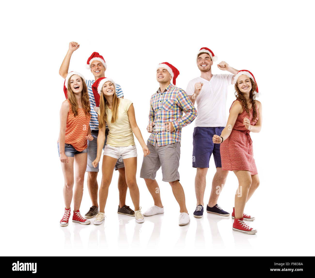 Group of young people in santa hats having fun, isolated on white ...