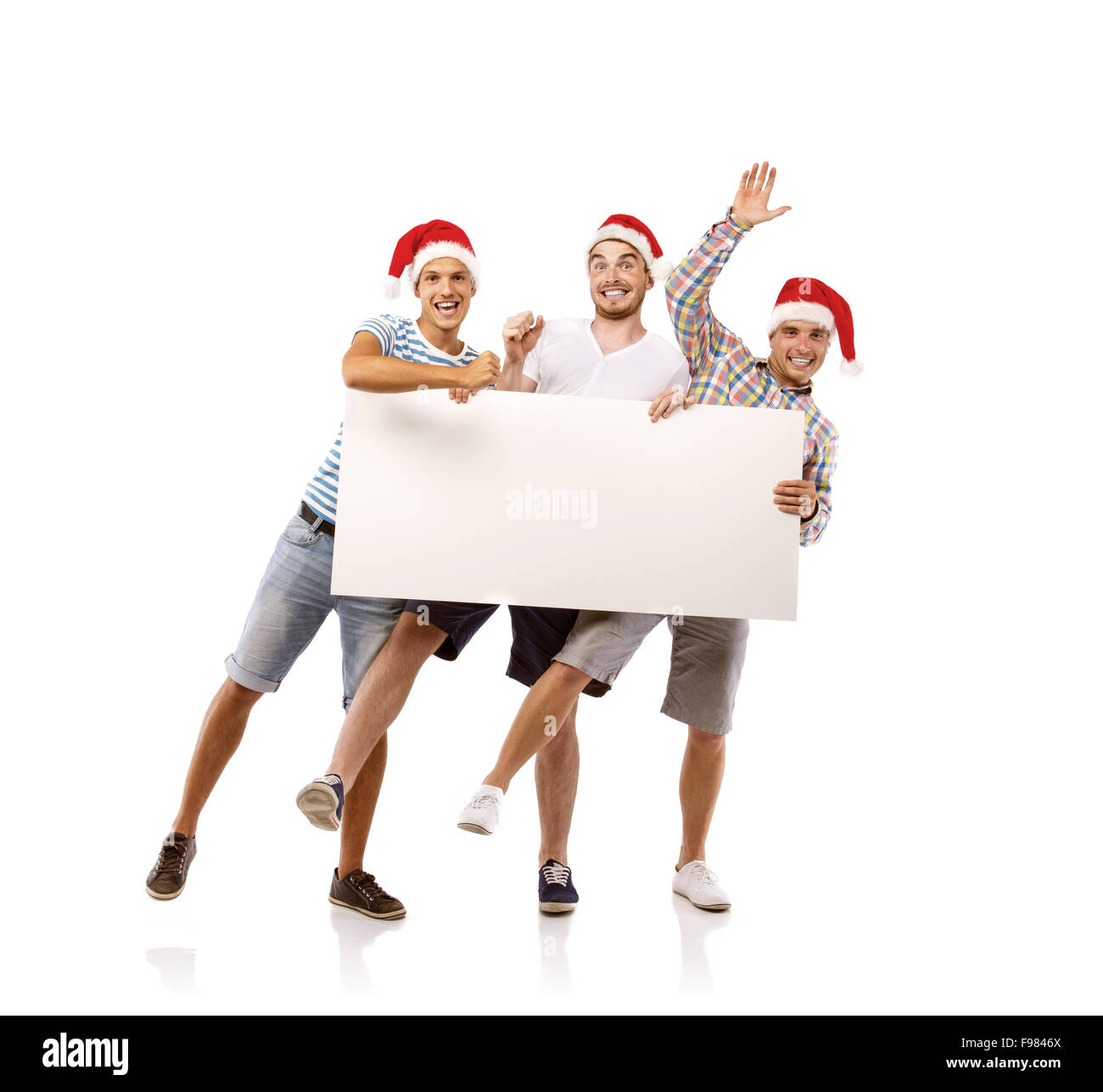 Three young men in santa hats with copy space, isolated on white ...