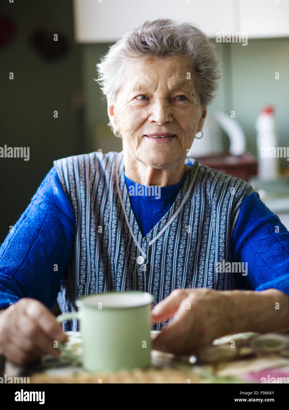 Old woman is drinking tea in her country style kitchen Stock Photo - Alamy