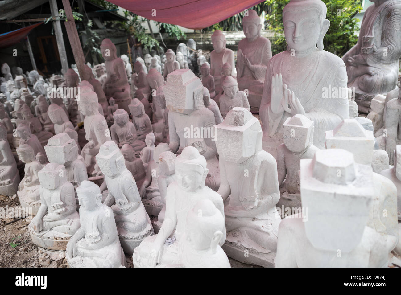 MANDALAY, Myanmar — An outdoor workshop yard displays finished and ...