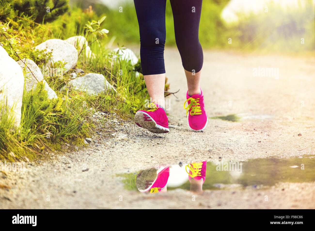 Senior runner woman feet running in beautiful nature reflecting in ...