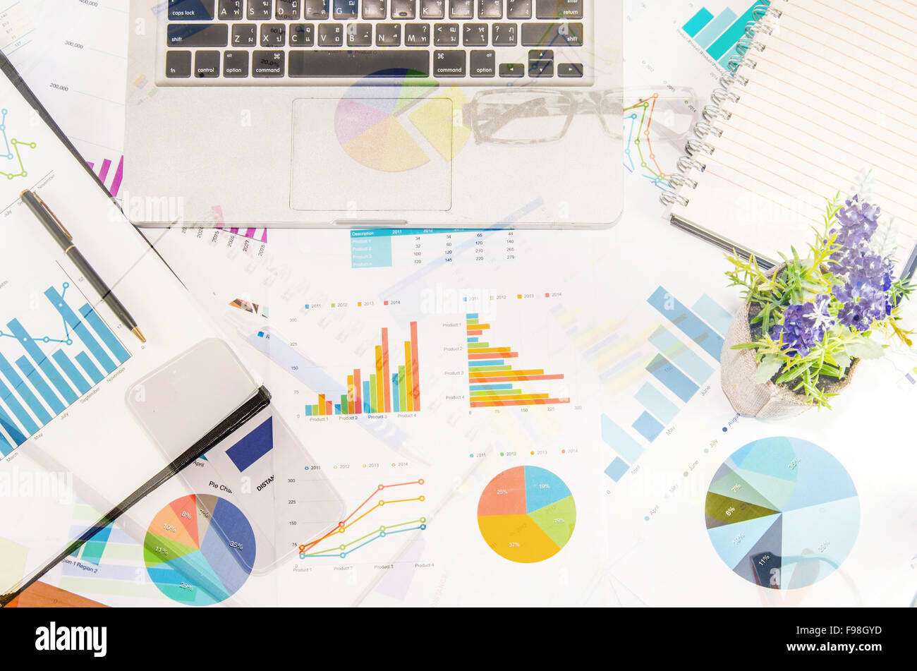 laptop, over papers with numbers and charts. View from above Stock ...