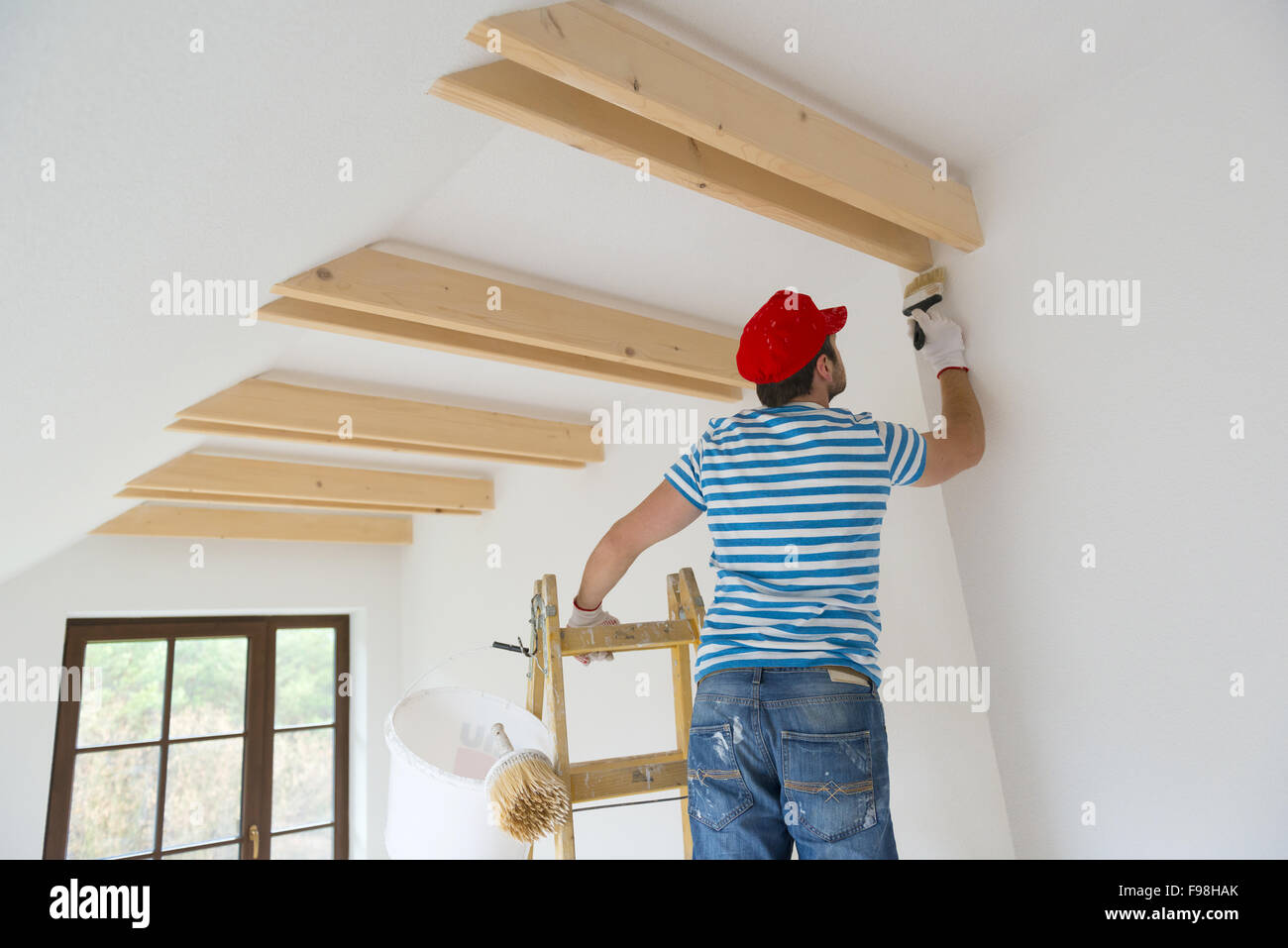 Happy smiling man painting the walls of new home with paintbrush Stock ...