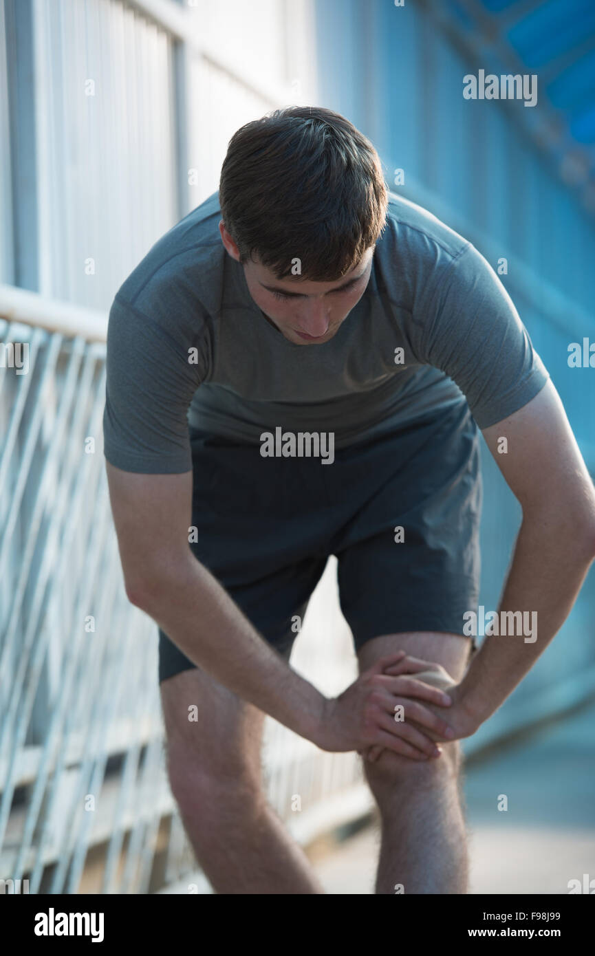 Attractive fit young man stretching before exercise, sunrise early ...