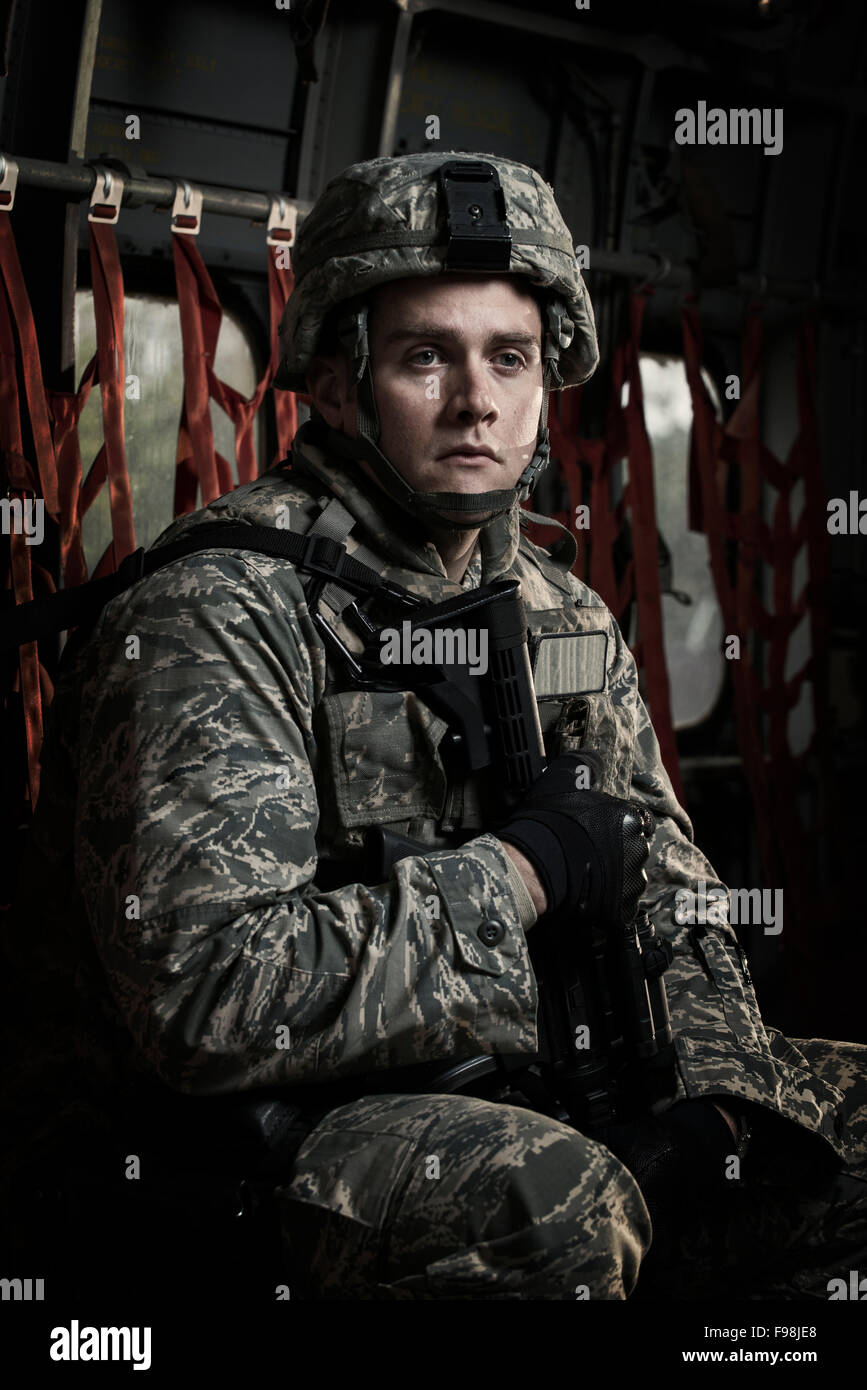 An Air Force Security Forces member sits aboard a military cargo ...