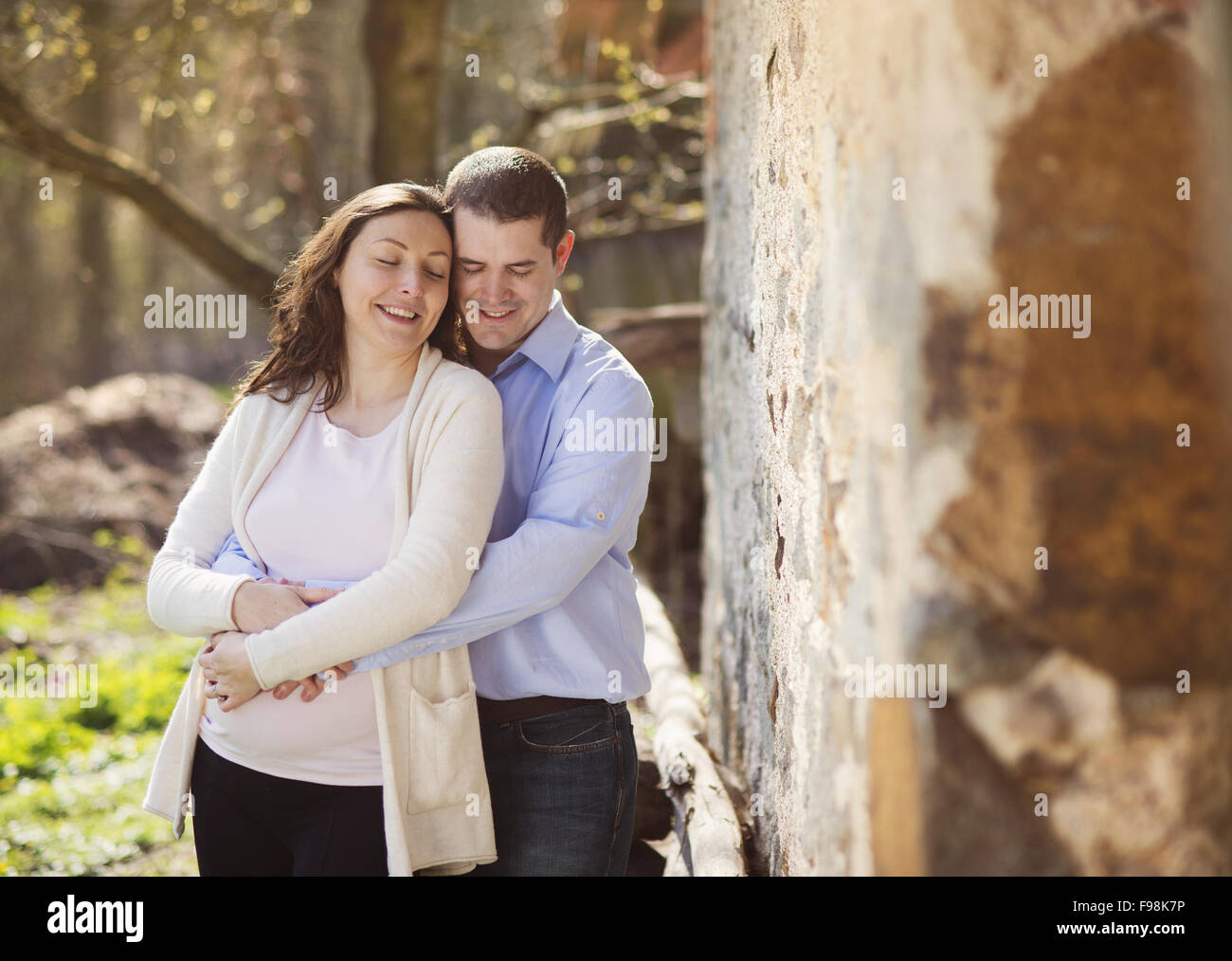 Happy young pregnant couple hugging in nature Stock Photo - Alamy
