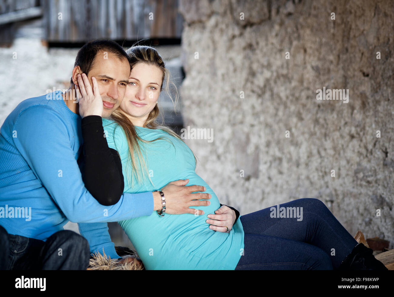 Happy and young pregnant couple hugging in nature Stock Photo - Alamy