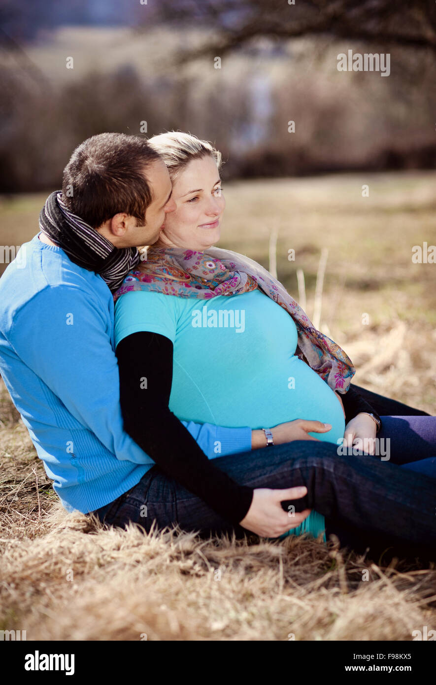 Happy and young pregnant couple hugging in nature Stock Photo - Alamy