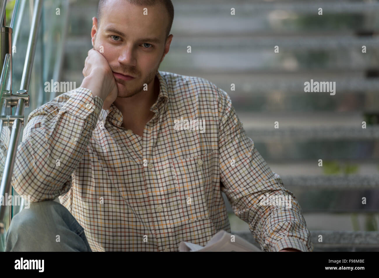 Handsome man reading a newspaper and thinking Stock Photo - Alamy