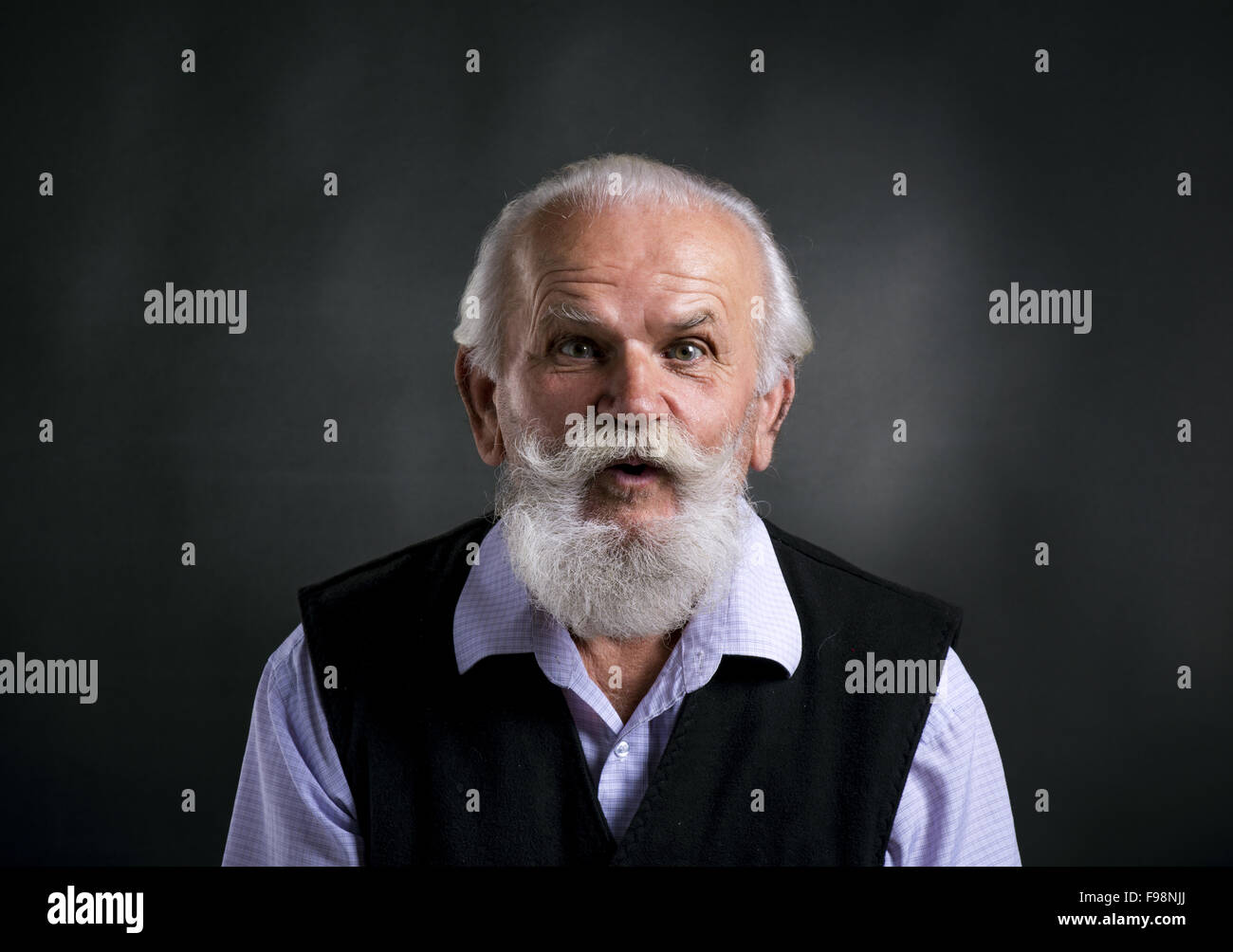 Portrait of surprised old bearded man, posing in studio on black ...