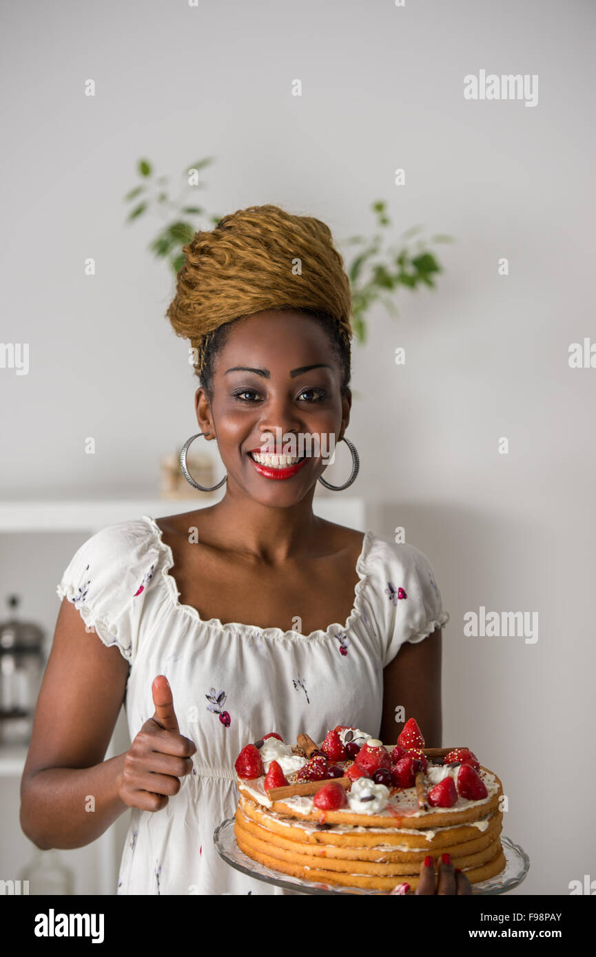 Beautiful young african woman cooking cake at kitchen Stock Photo - Alamy