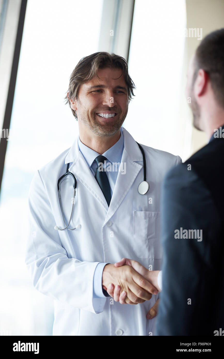 doctor handshake with a patient at doctors bright modern office in ...