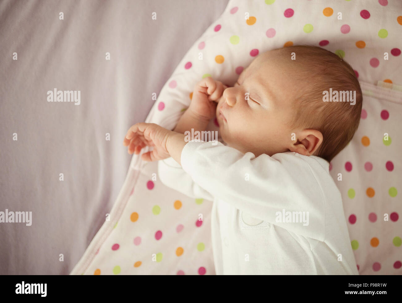 Cute newborn baby girl sleeping in bed at home Stock Photo - Alamy
