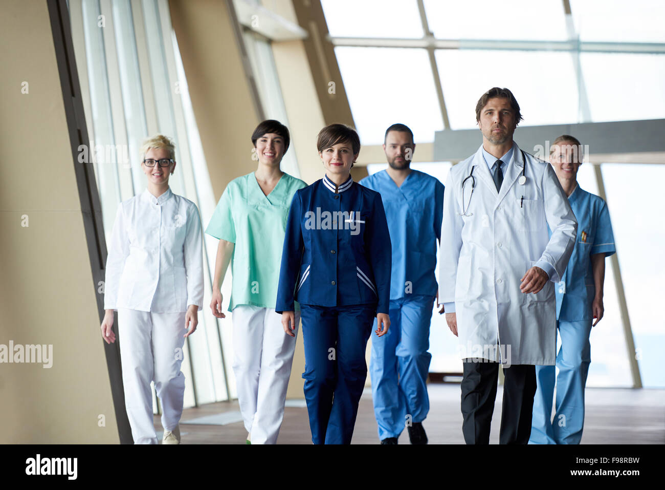 doctors team walking in modern hospital corridor indoors, poeople group ...