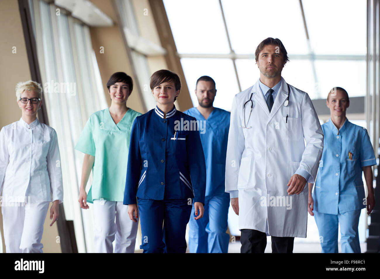 doctors team walking in modern hospital corridor indoors, poeople group ...