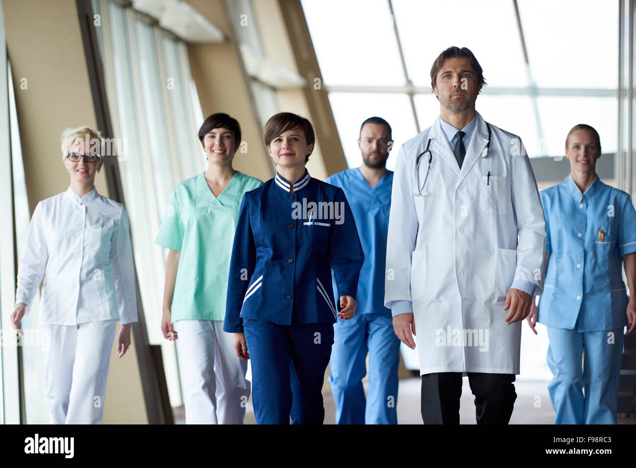 doctors team walking in modern hospital corridor indoors, poeople group ...