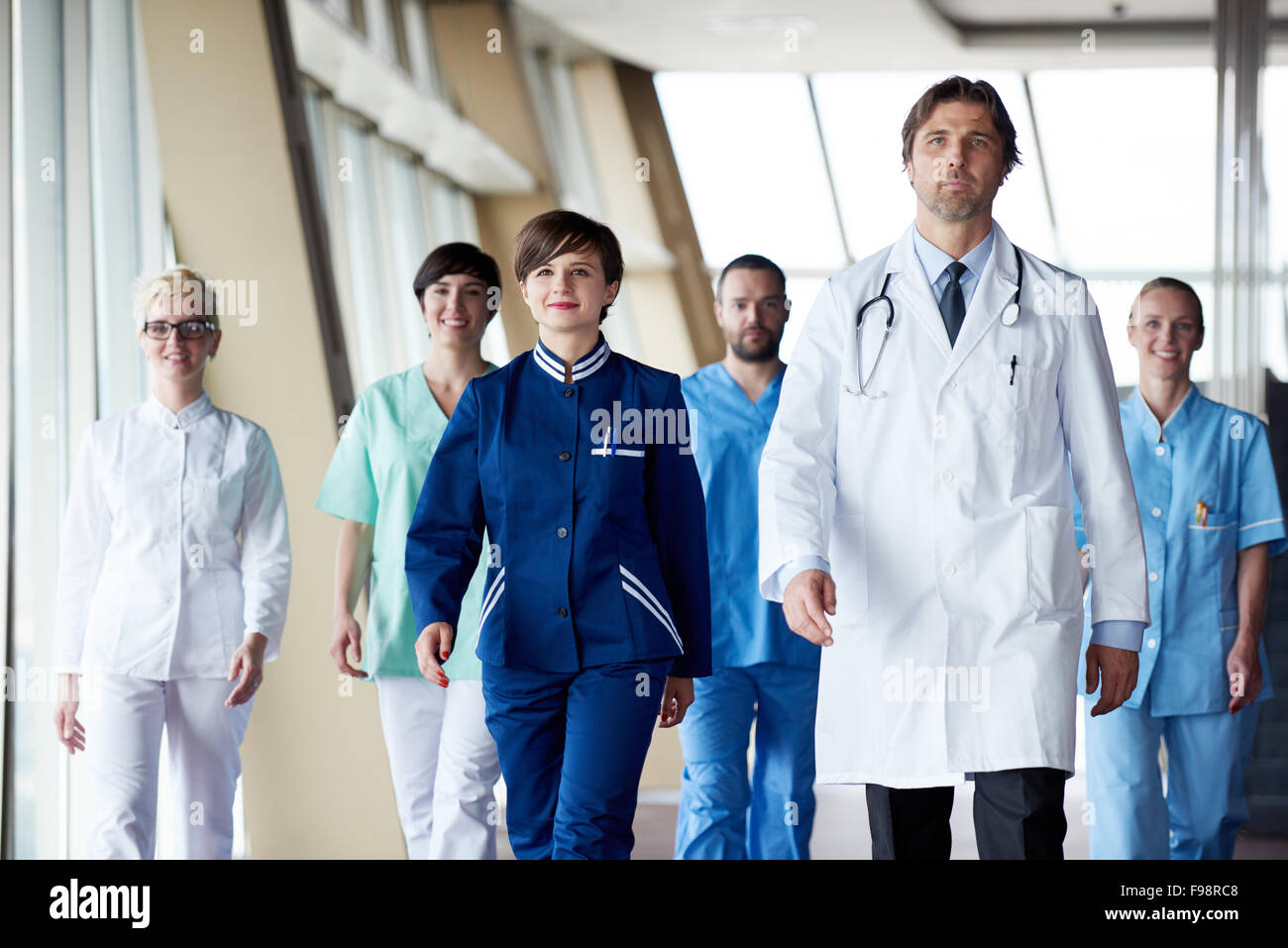 doctors team walking in modern hospital corridor indoors, poeople group ...