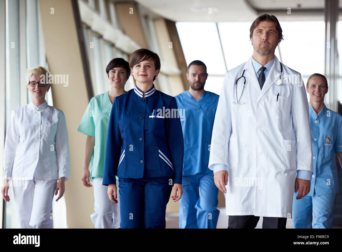 doctors team walking in modern hospital corridor indoors, poeople group ...