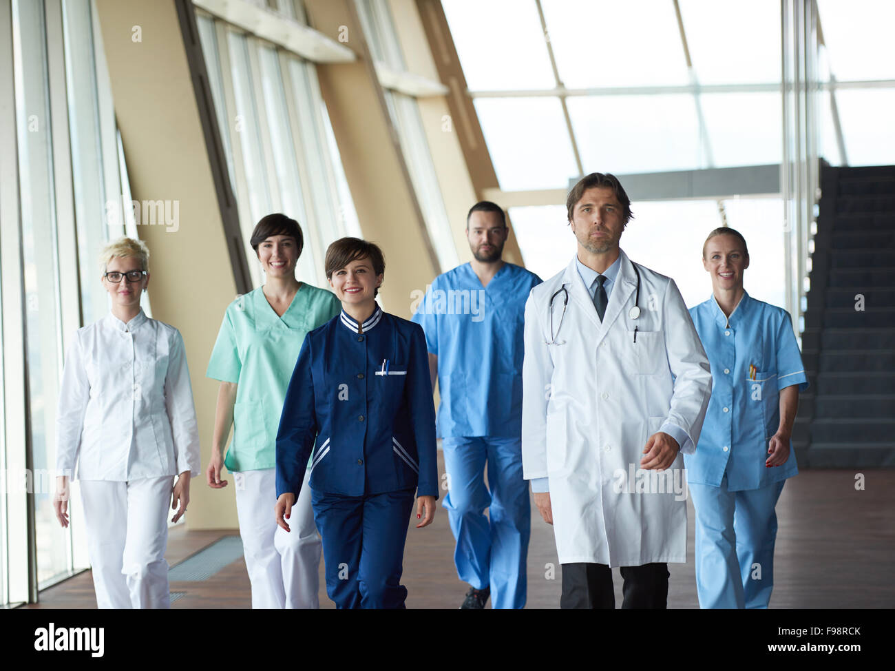 doctors team walking in modern hospital corridor indoors, poeople group ...