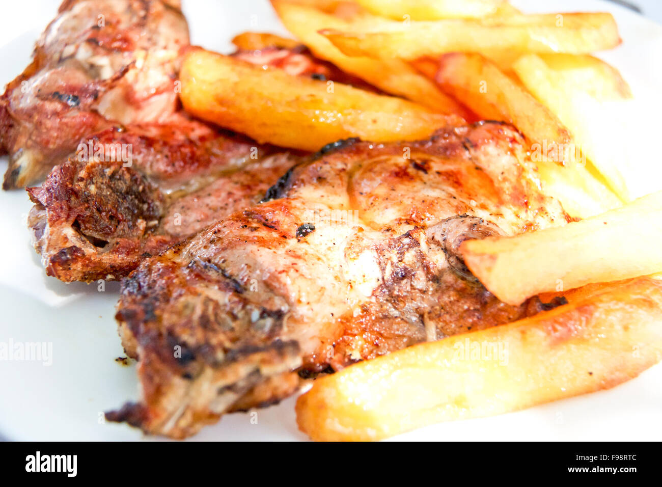 Lamp chop with french fries and tomatoes Stock Photo - Alamy