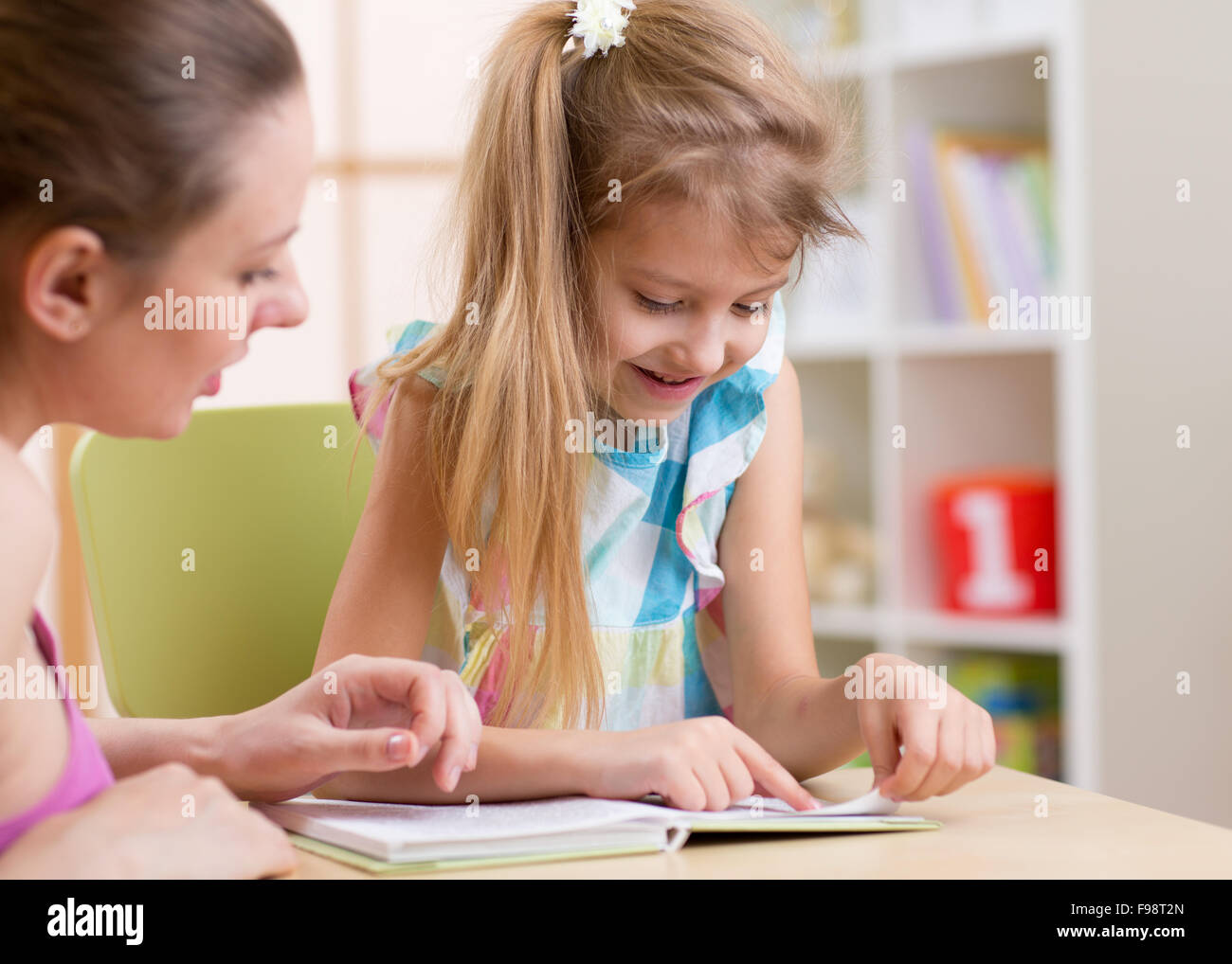 Mother teaching her daughter to read hi-res stock photography and ...