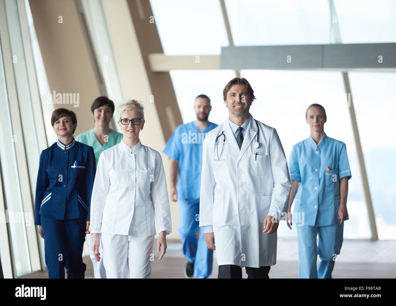 doctors team walking in modern hospital corridor indoors, poeople group ...