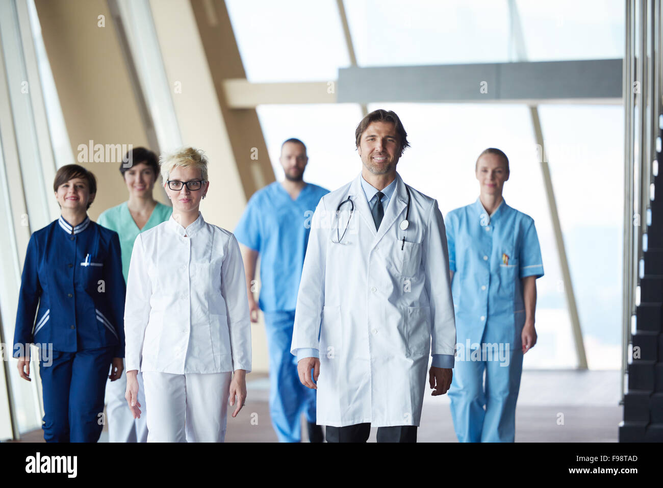 doctors team walking in modern hospital corridor indoors, poeople group ...