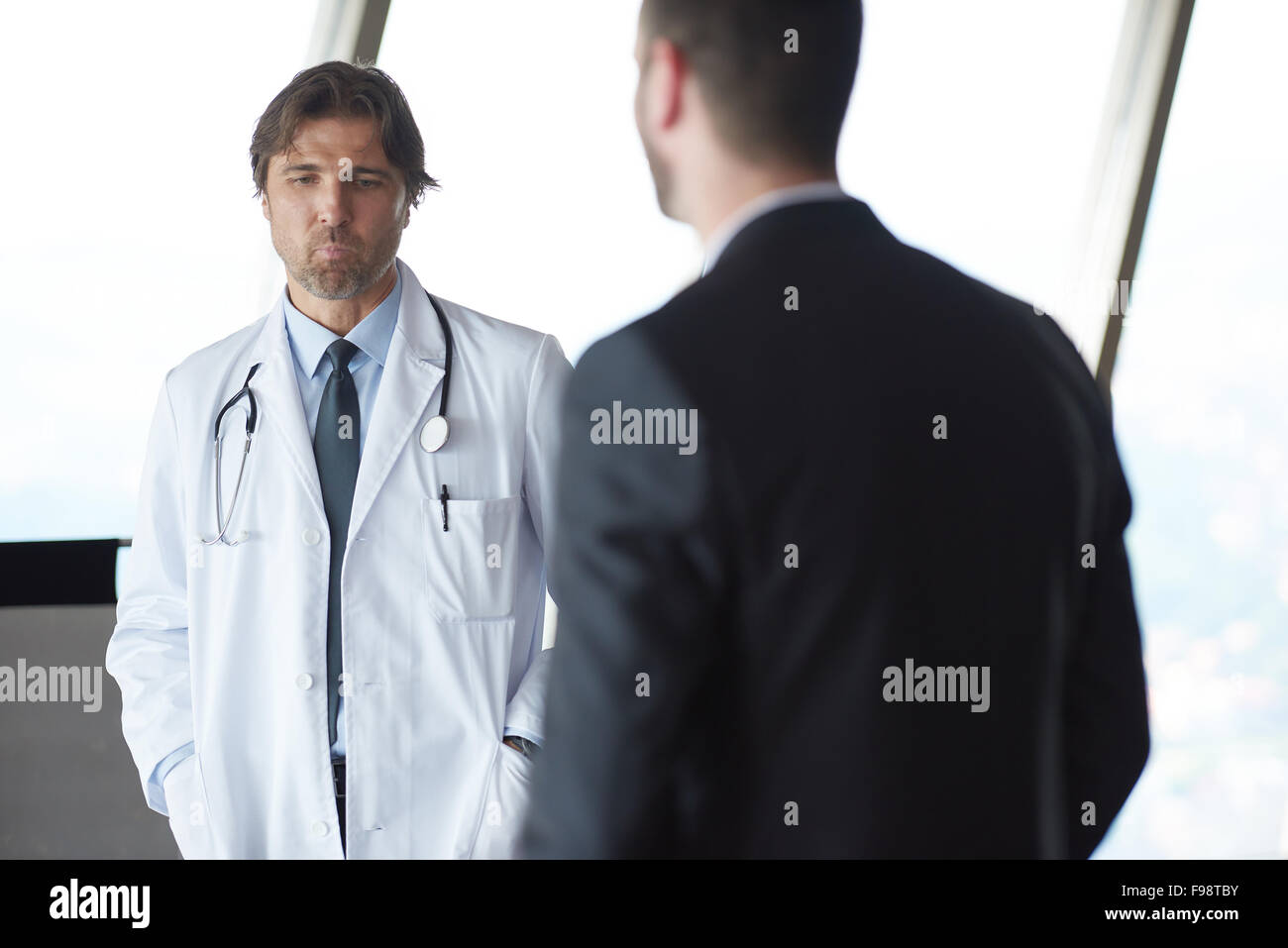 doctor handshake with a patient at doctors bright modern office in ...