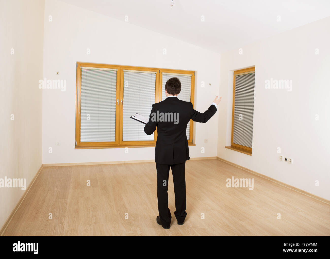 Real Estate Agent is standing in new empty house Stock Photo - Alamy