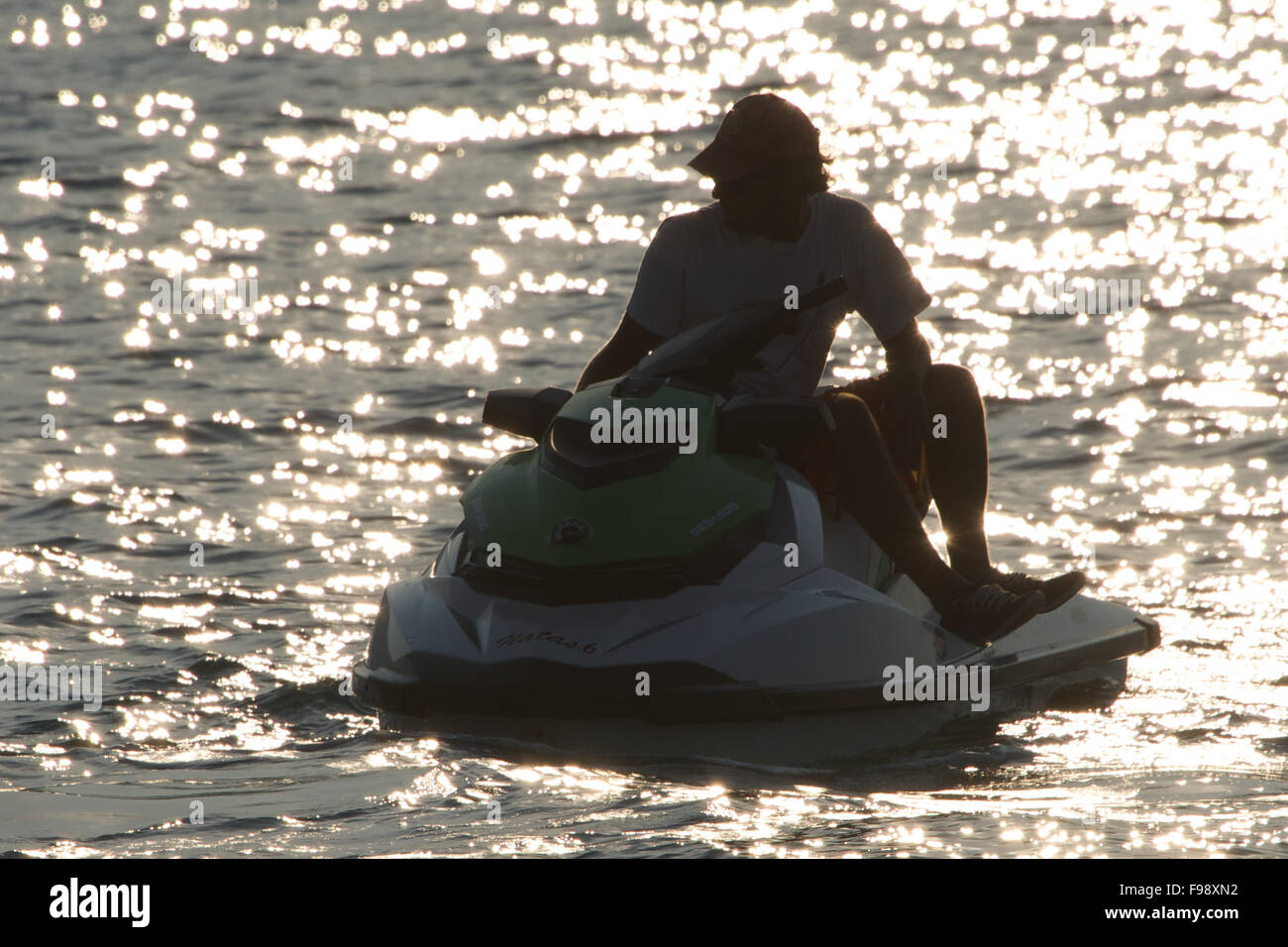 Jet Ski driver silhouetted against backlit waves Stock Photo - Alamy