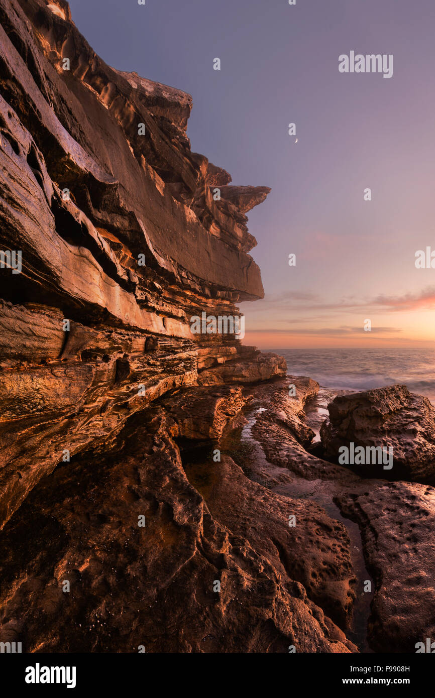 Seascape with large cliff and rocks and Moon Stock Photo - Alamy