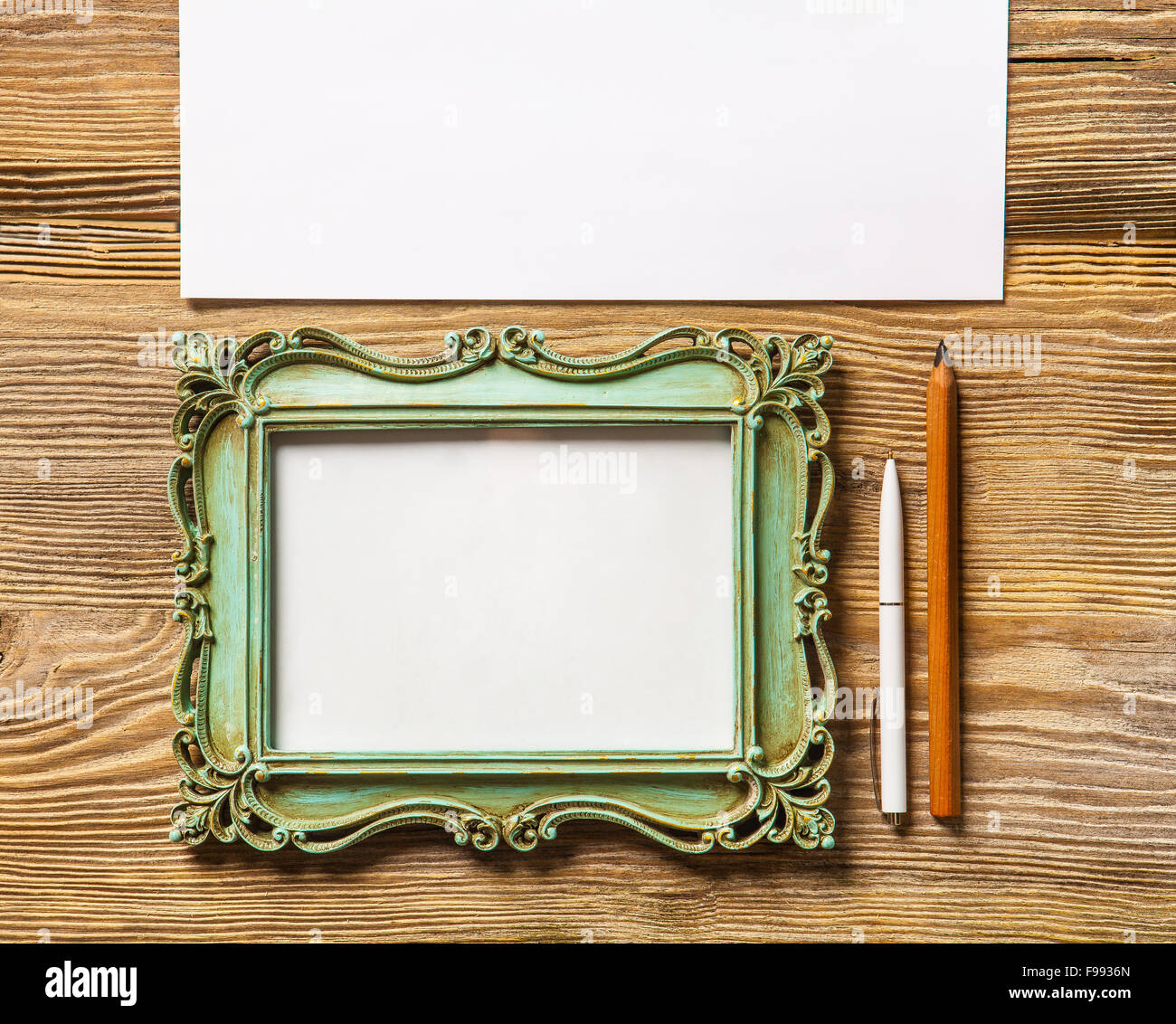 The mockup on wooden background with vintage old picture frame, pen ...