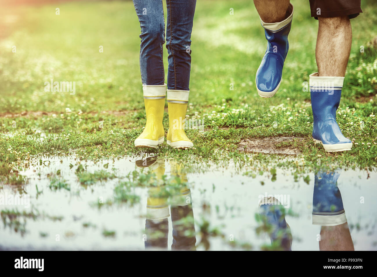 Young couple in colorful wellies walking in muddy nature. Details of ...