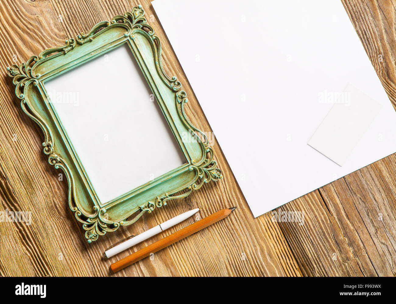 The mockup on wooden background with vintage old picture frame, pen ...