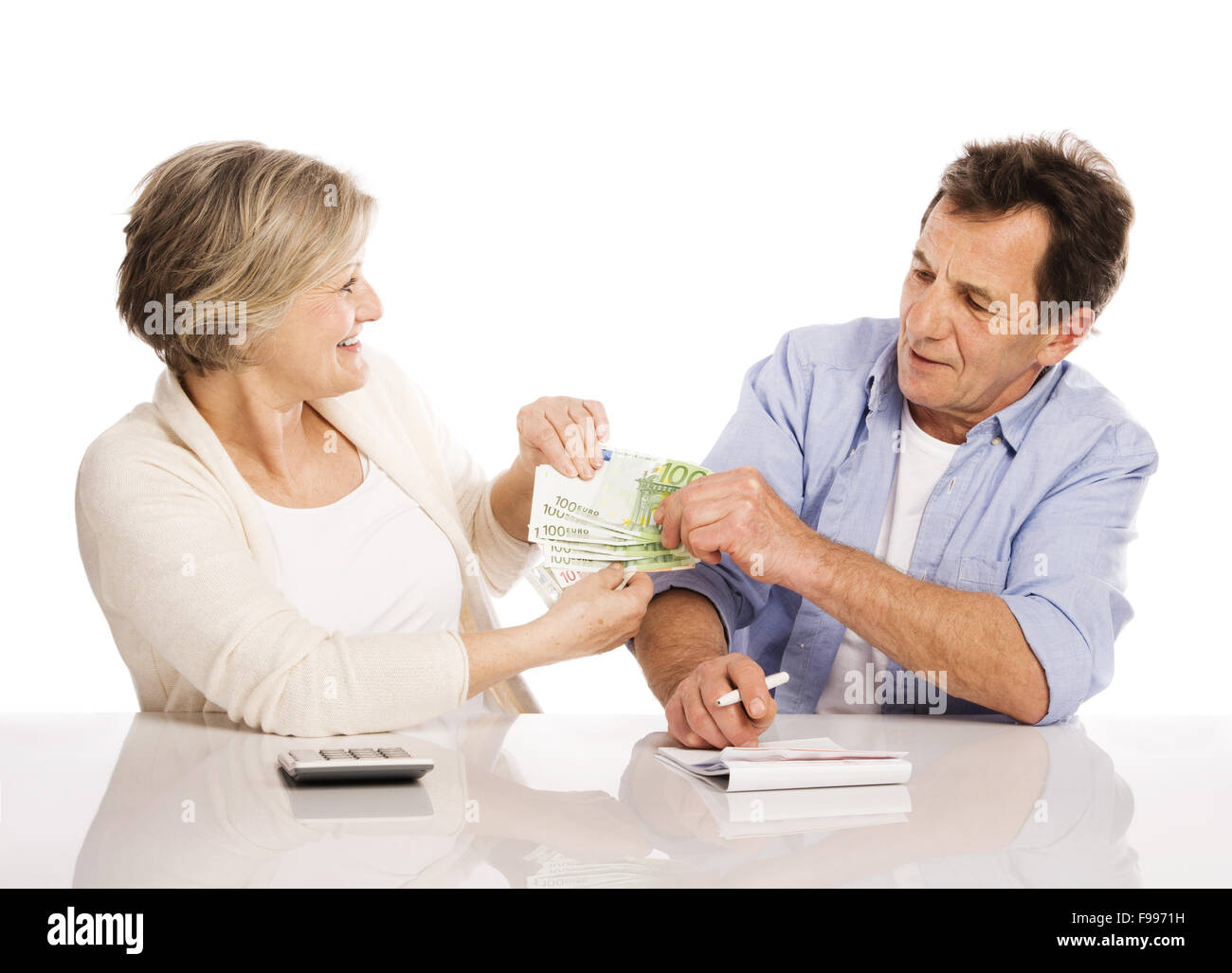 Senior couple counting money at the table, isolated on white background ...