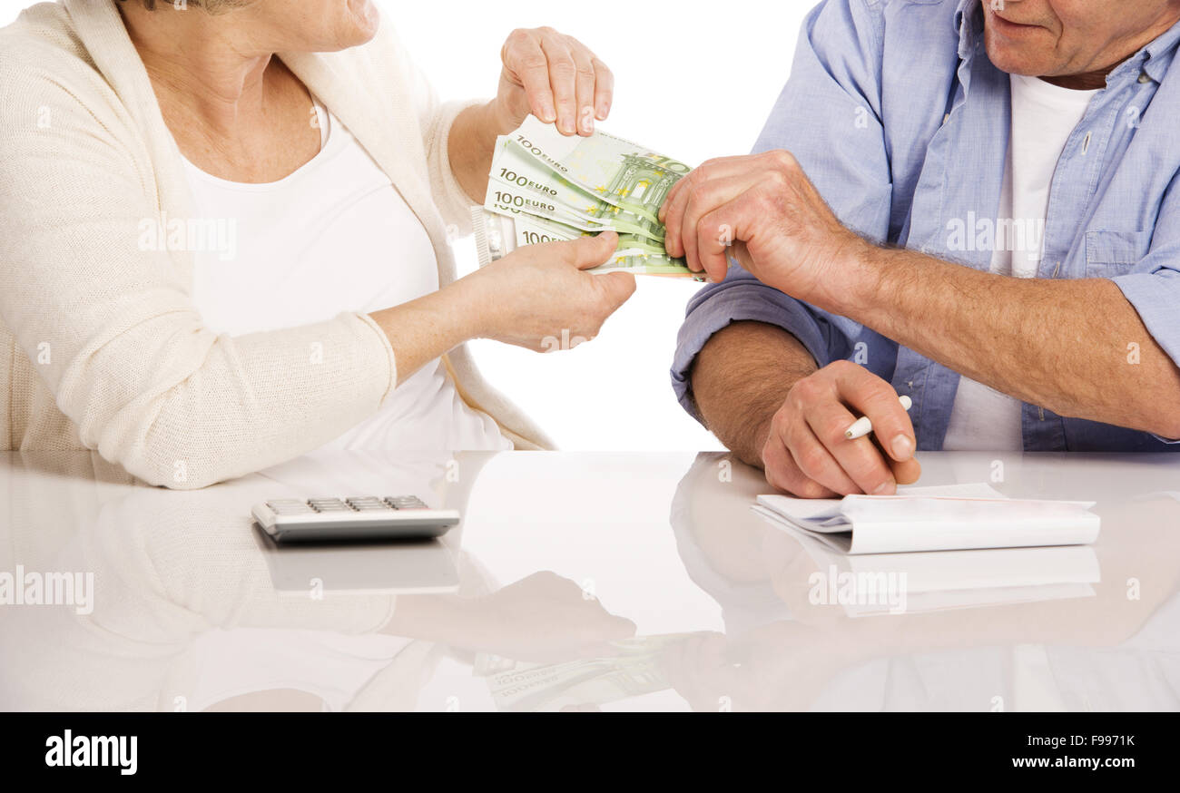 Senior couple counting money at the table, isolated on white background ...