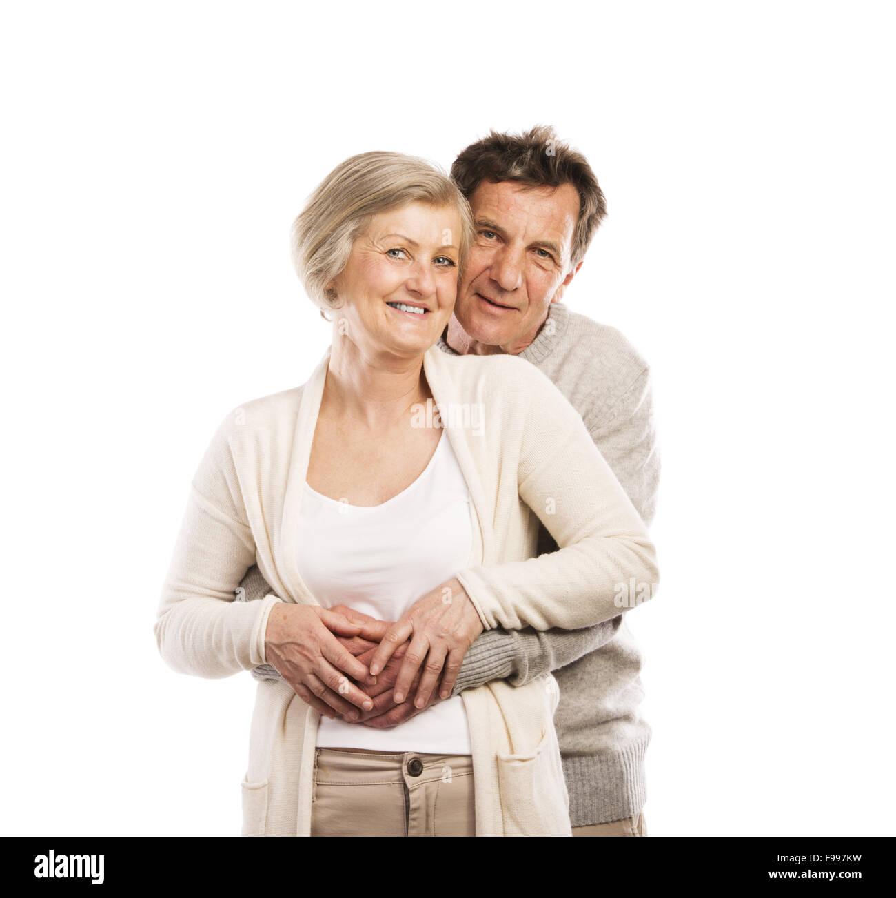 Studio portrait of happy seniors couple hugging. Isolated on white ...