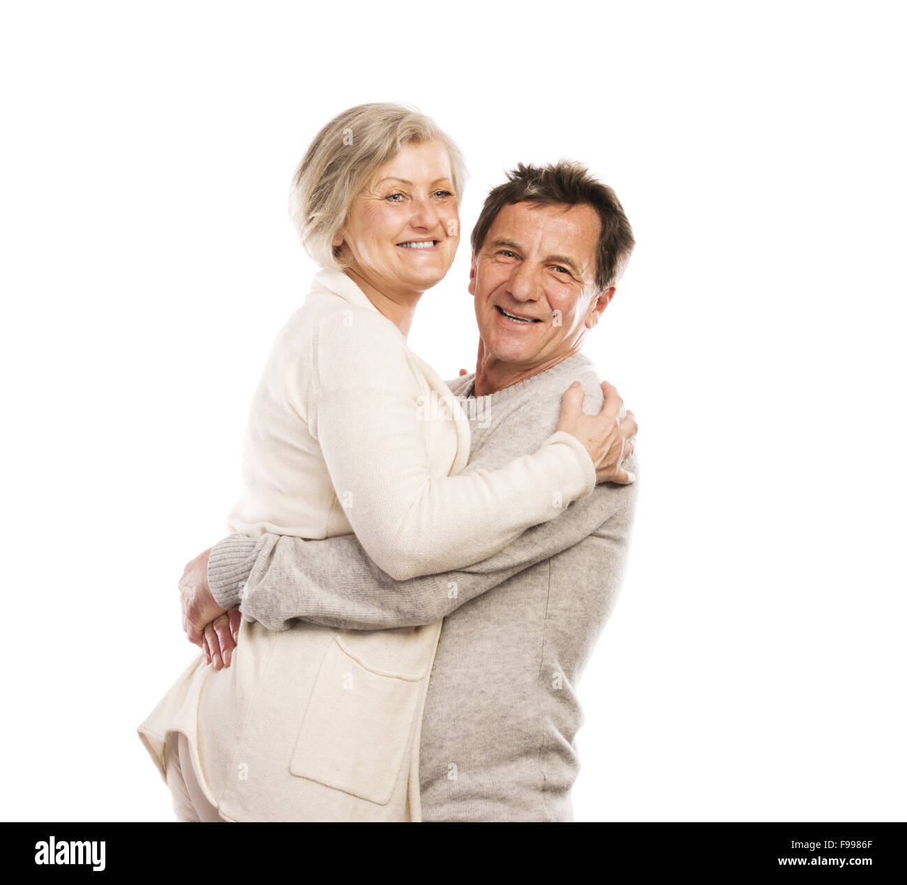 Studio portrait of happy seniors couple hugging. Isolated on white ...