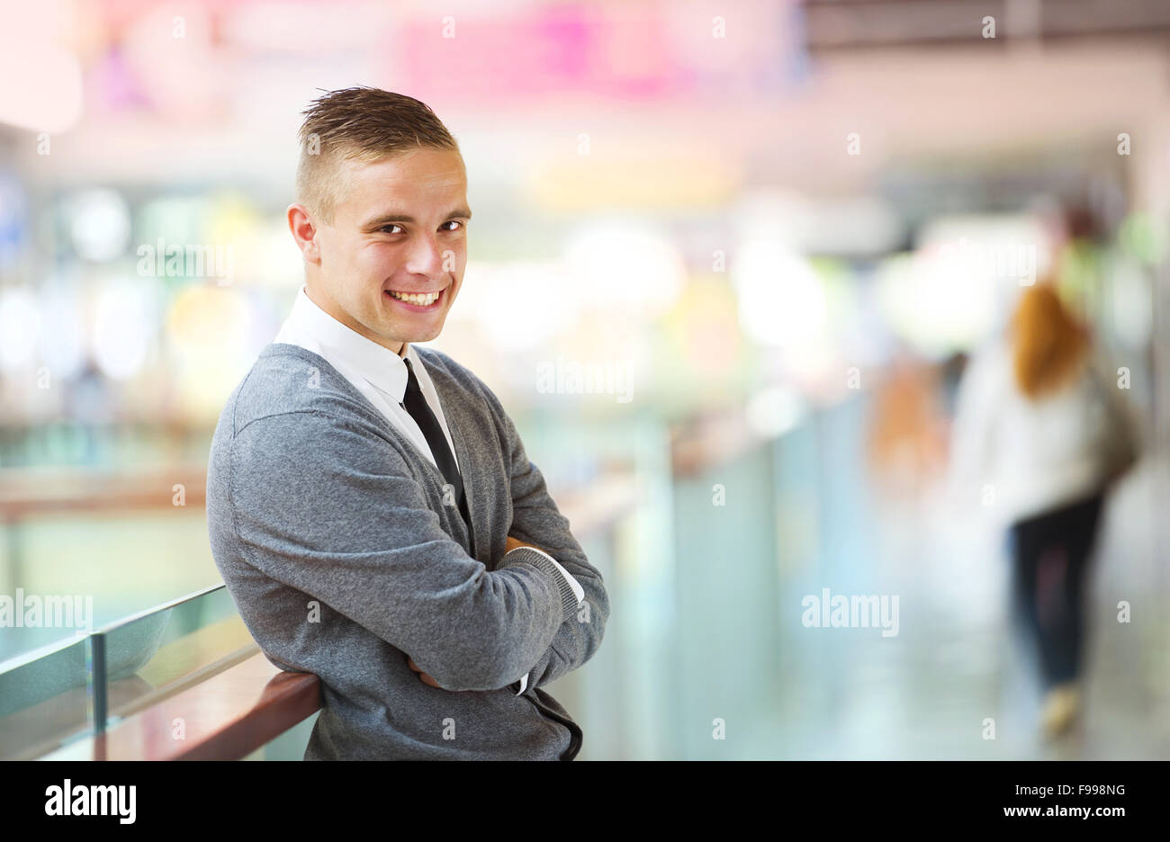 Handsome man standing and smiling in shopping centre Stock Photo - Alamy
