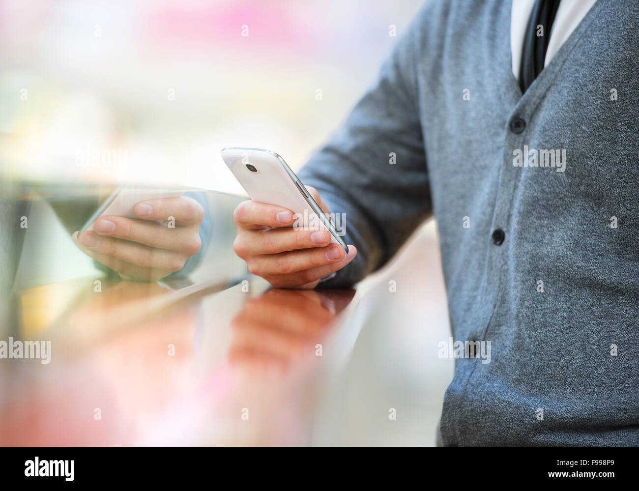 Handsome young man in shopping mall using mobile phone Stock Photo - Alamy